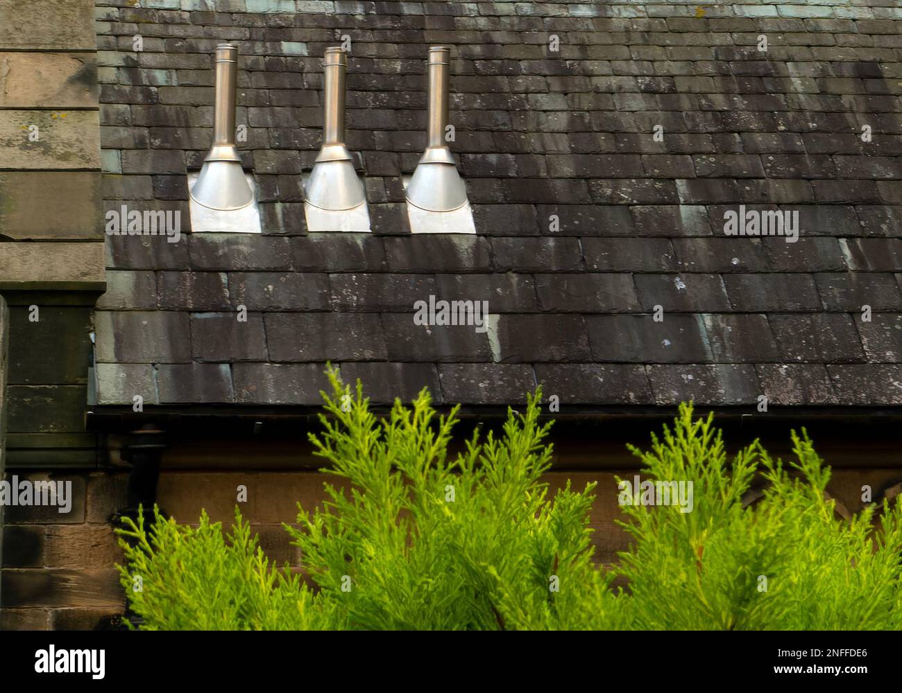 three metal chimneys on the roof Stock Photo - Alamy