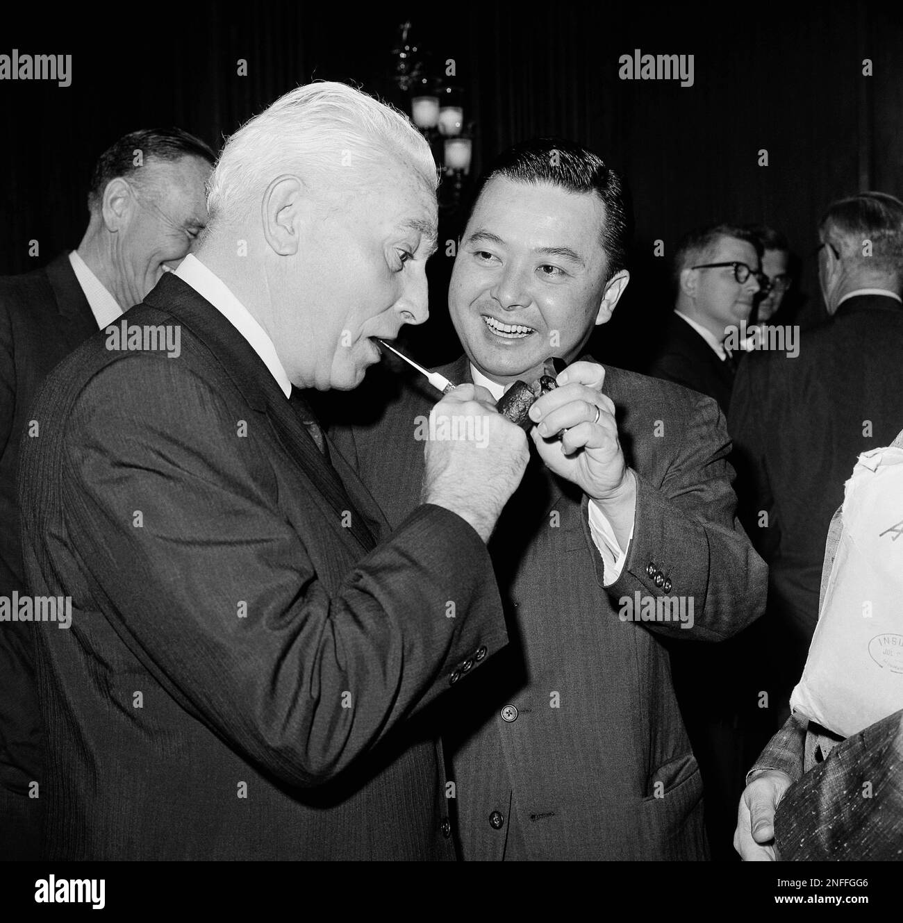 Sen. Daniel K. Inouye, D-Hawaii, lights the pipe of Sen. Thomas J. Dodd ...