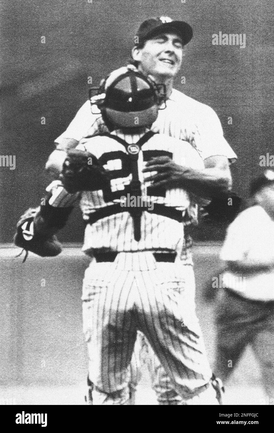 New York Yankee Dave Righetti leaps into the arms of catcher Butch ...