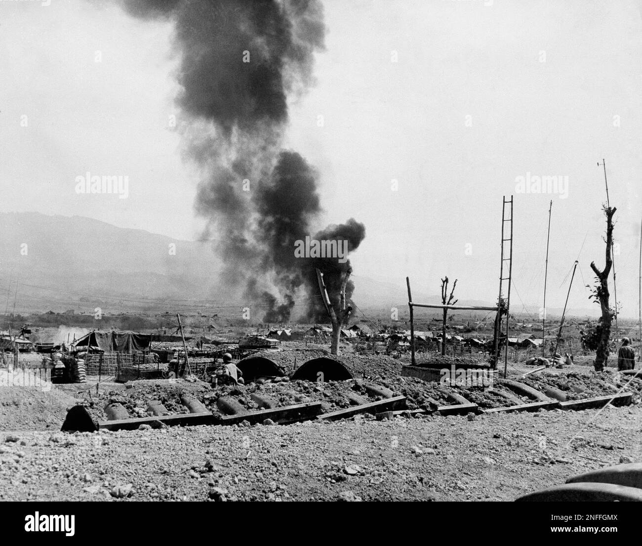 Napalm bombs burst over trenches occupied by Communist-led Vietminh ...