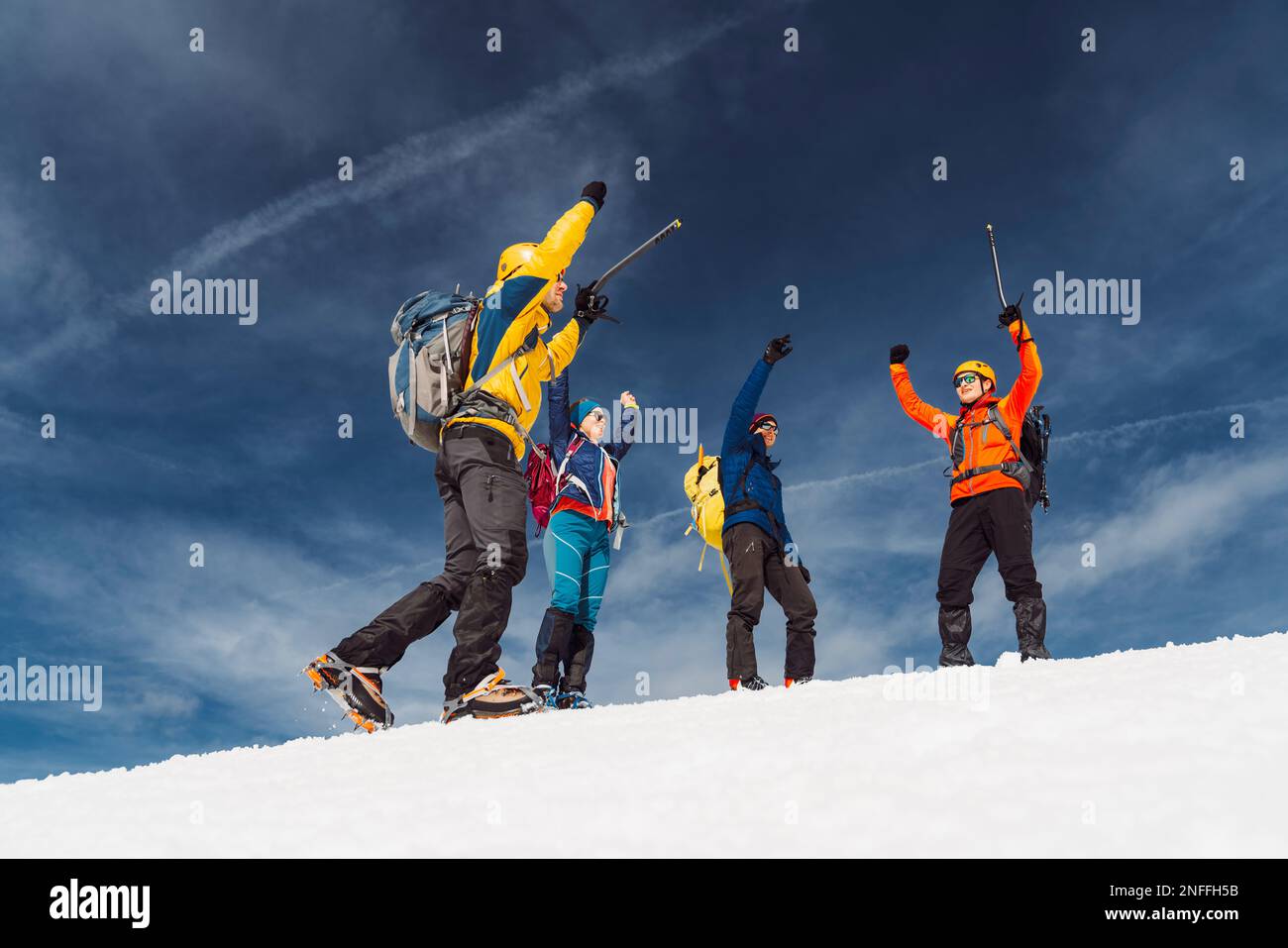 Group of happy hikers with their hands up in the air getting excited to ...