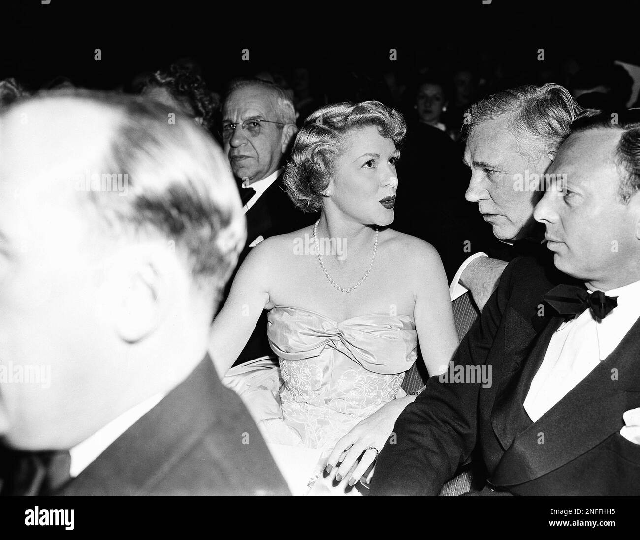 Actor Walter Huston, center, learns forward to match a word from Claire ...
