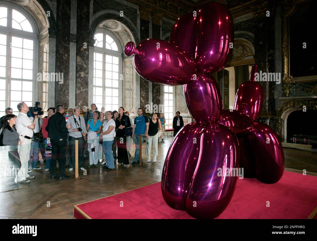Visitors watch "Balloon dog", by US artist Jeff Koons, in the chateau ...