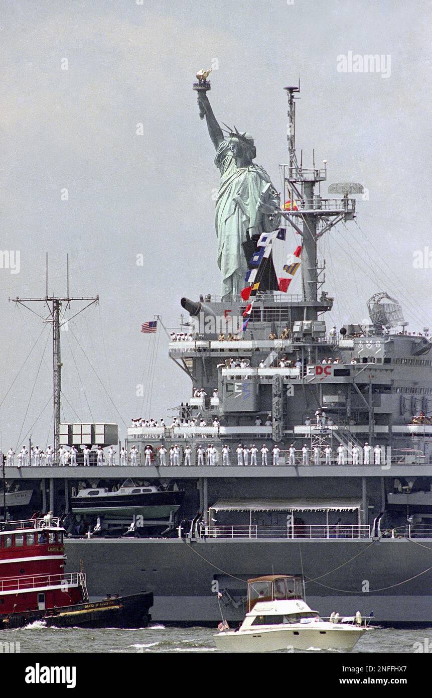 Sailors stand at attention on the desk of the USS Mount Whitney, an ...