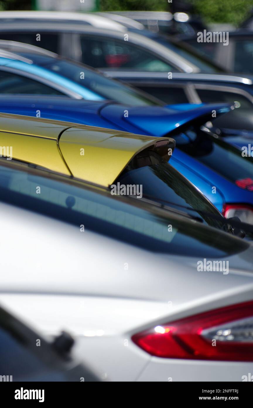 Cars fill a car park. The cars are gold, blue, and silver Stock Photo ...