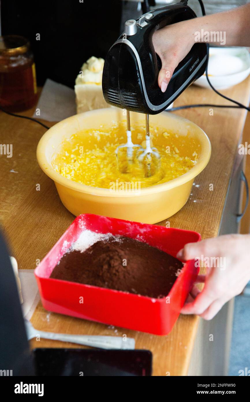 A housewife in the process of baking a cake in the kitchen - mixing the ...