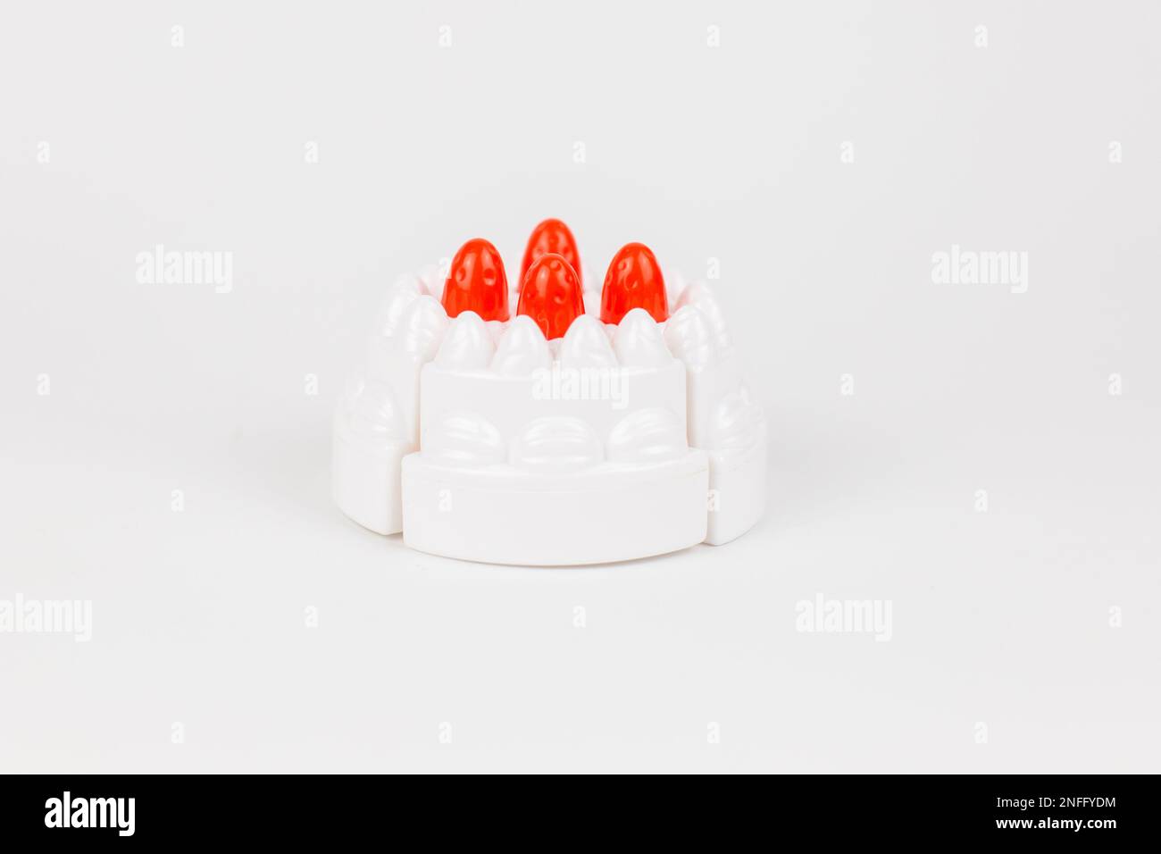 a plastic toy children's cake with white cream on a white background ...