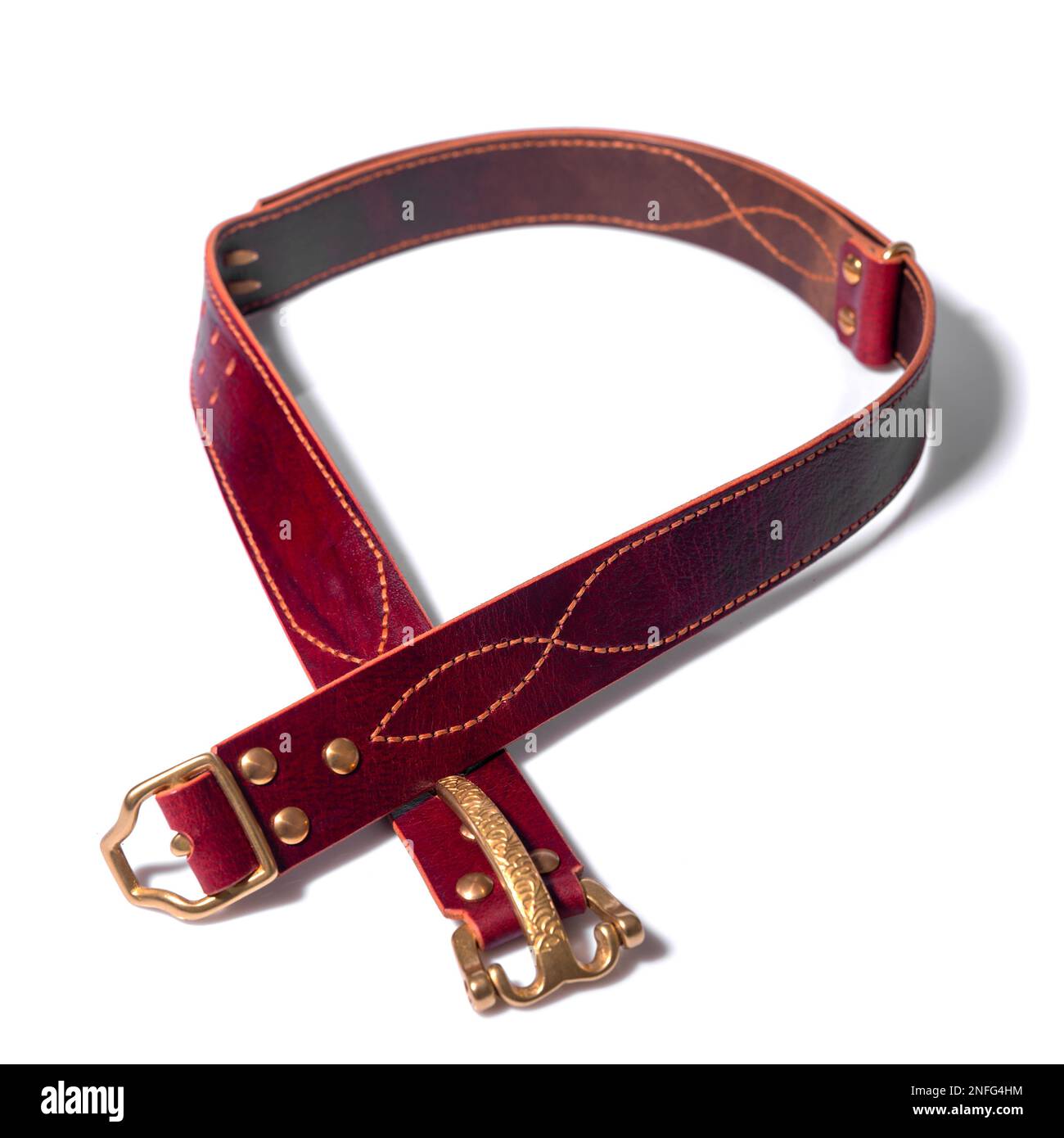 A rolled-up brown leather belt with a metal buckle on a white ...
