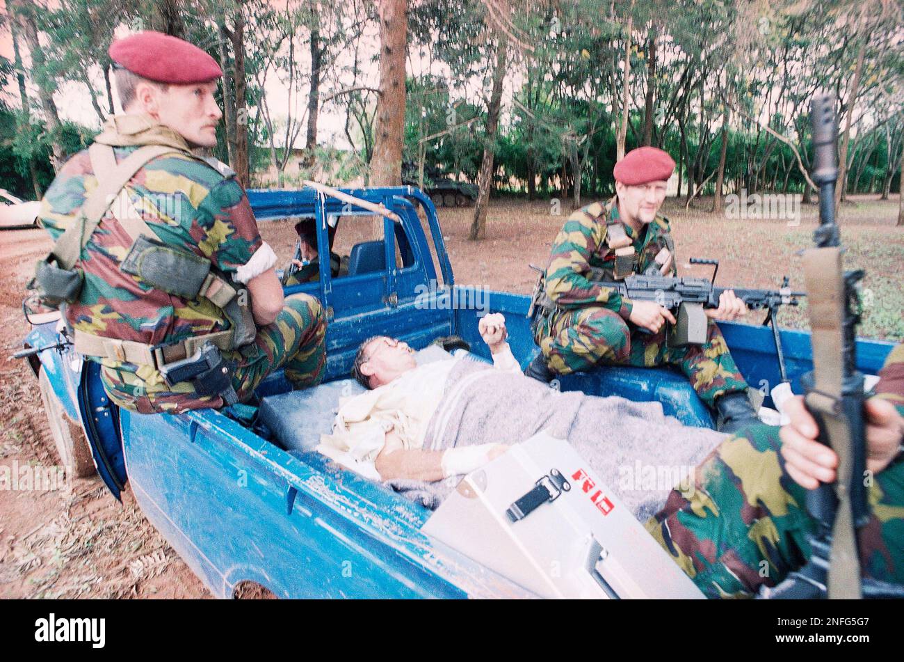 Belgian soldiers protect a wounded Belgian resident on the back of a ...