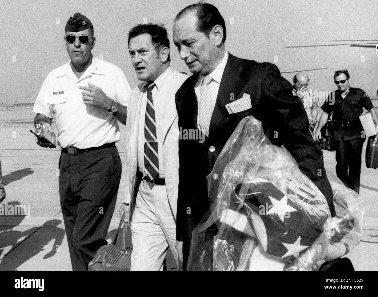 U.S. Ambassador to Cambodia John Gunther Dean carries the American flag ...