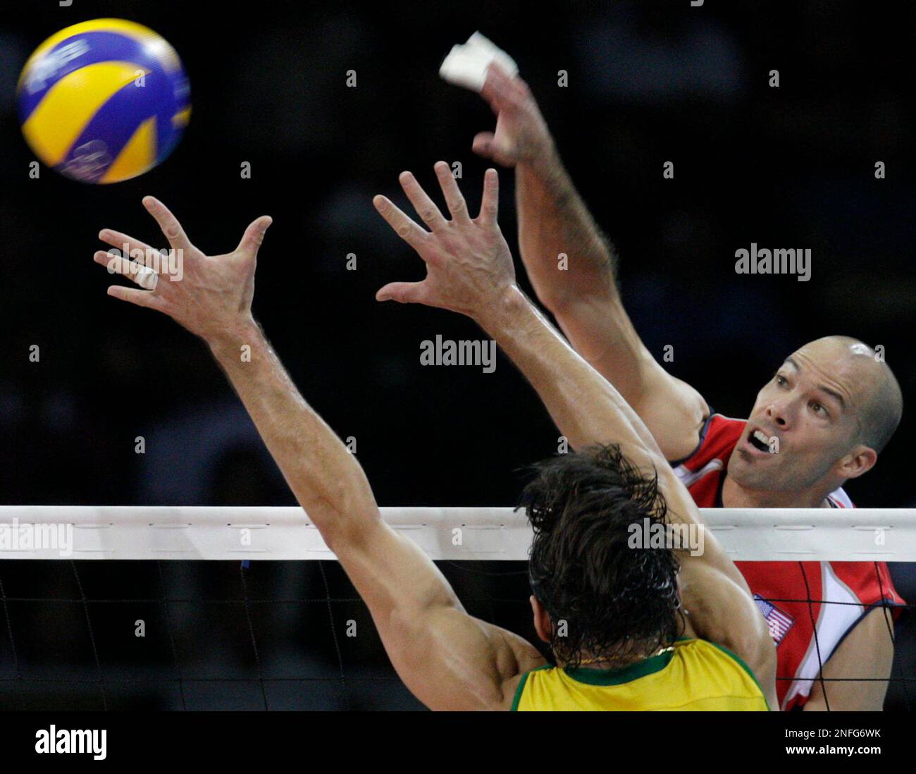 USA's William Priddy, in red, spikes against Brazil's Gilberto Godoy ...