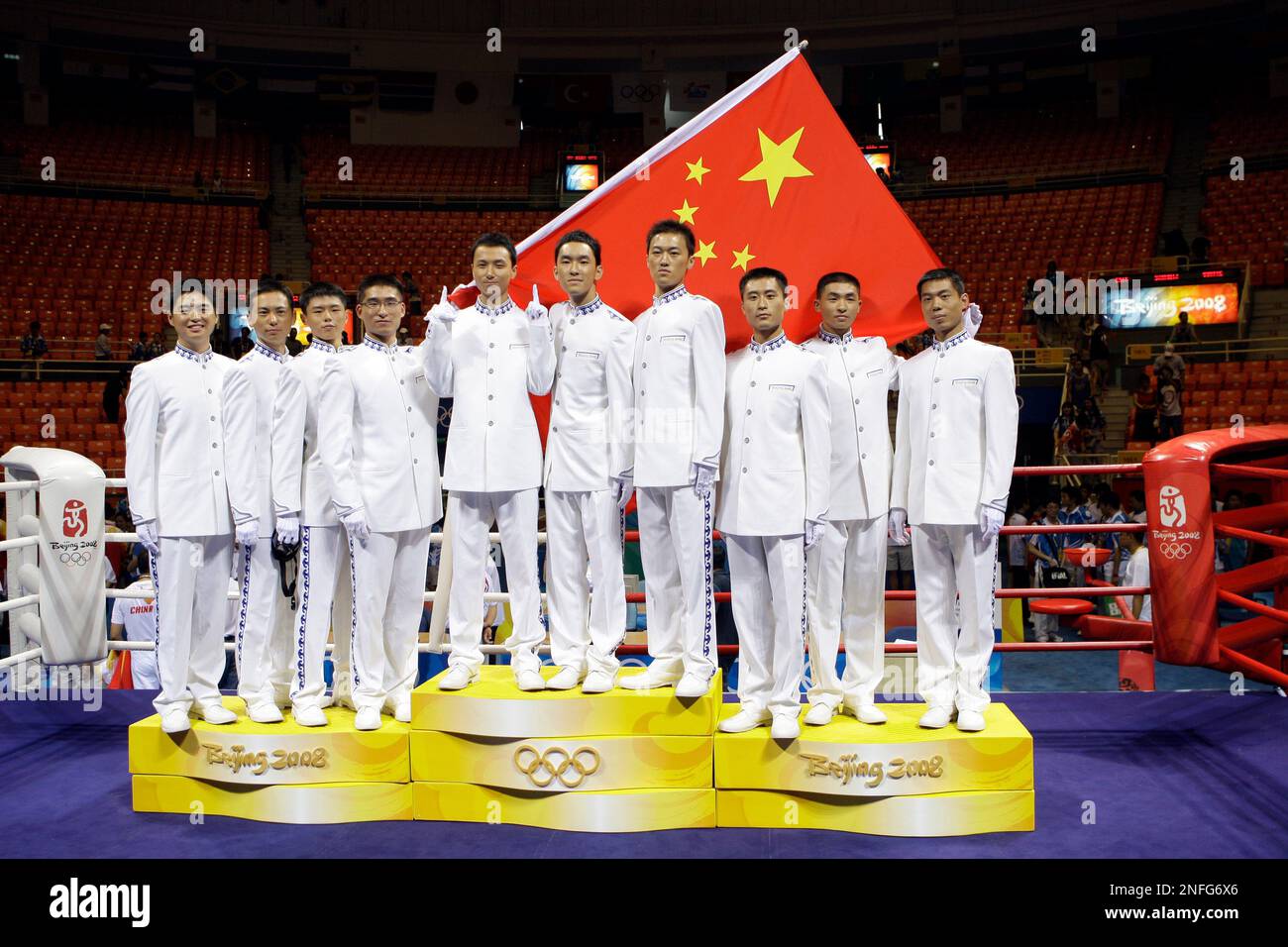 Young Chinese men pose with their national flag on the podium following ...