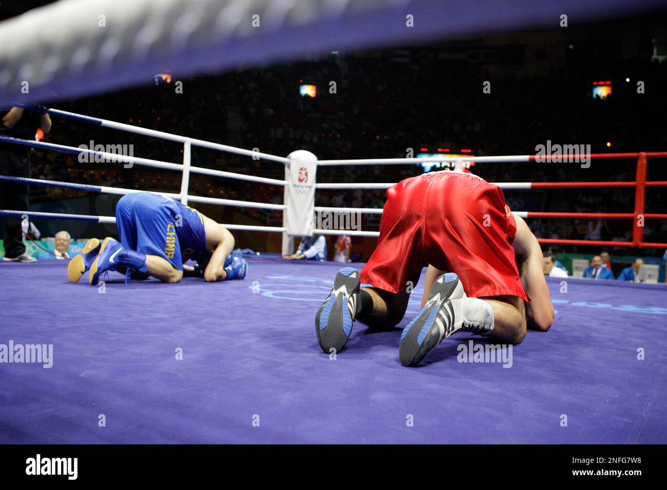 Kenny Egan of Ireland, red, and Zhang Xiaoping of China, blue, both fall to their knees ...