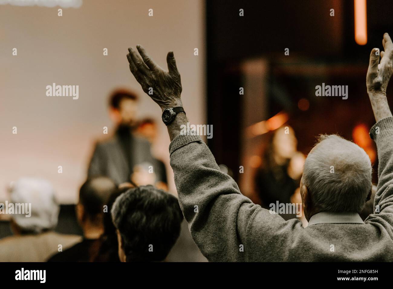 Elder man rise his hand while he is praise God at church service Stock ...