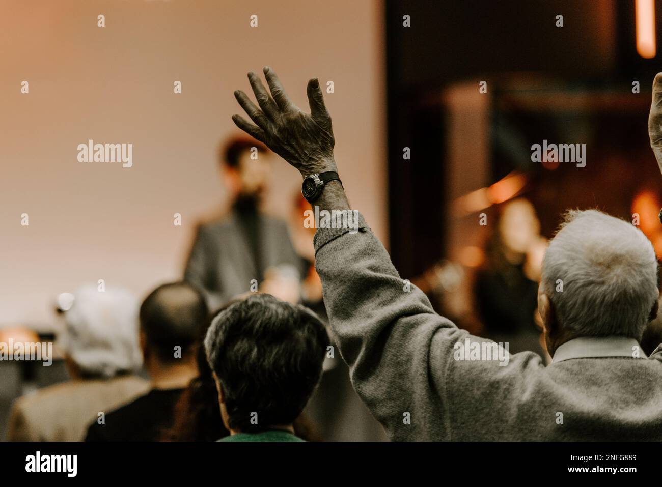 Elder man rise his hand while he is praise God at church service Stock ...
