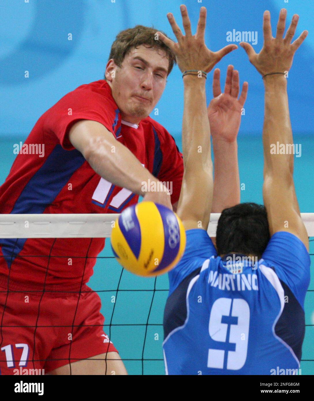 Russia's Maxim Mikhaylov, left, spikes against Italy's Matteo Martino ...