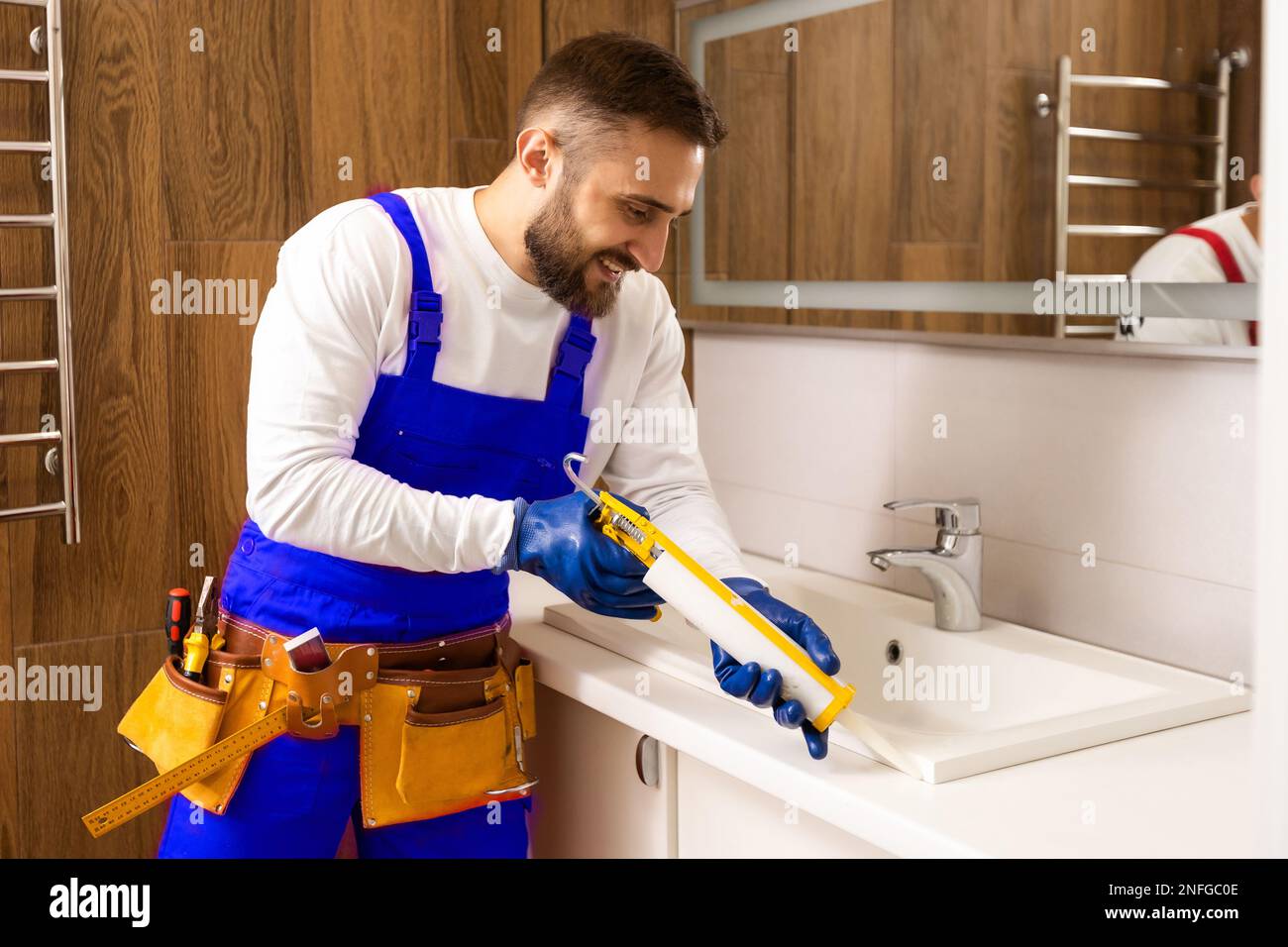 a worker installs a wash basin in a bathroom Stock Photo - Alamy