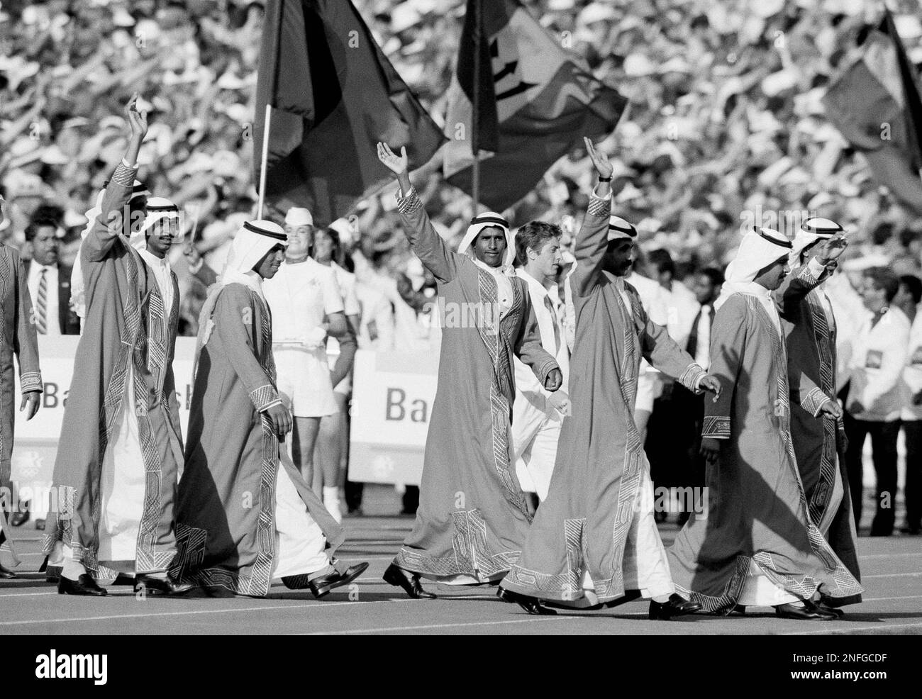 The Olympic team from Bahrain, wearing traditional dress, wave to the ...
