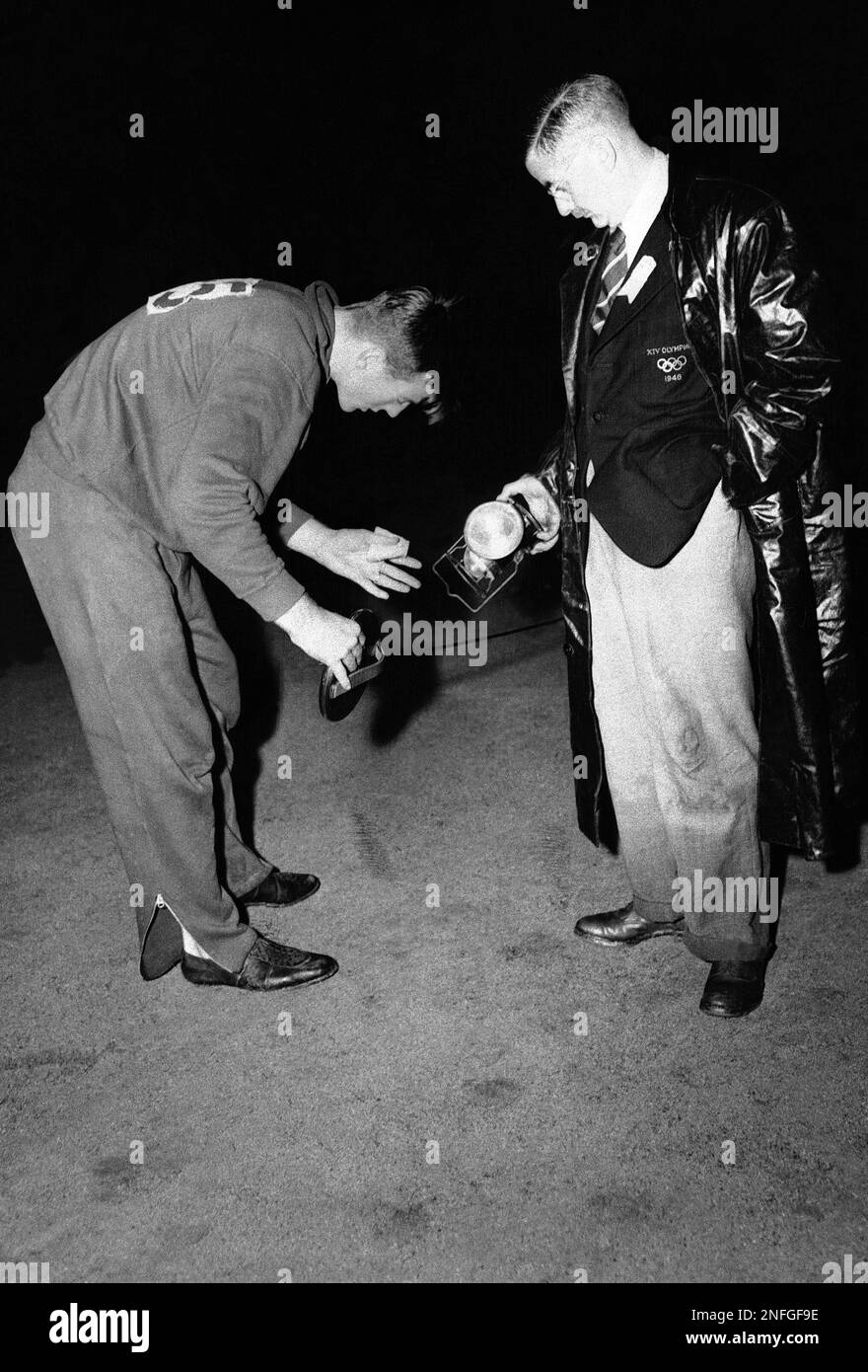 Bob Mathias, winner of the Olympic decathlon, measures his run for the ...