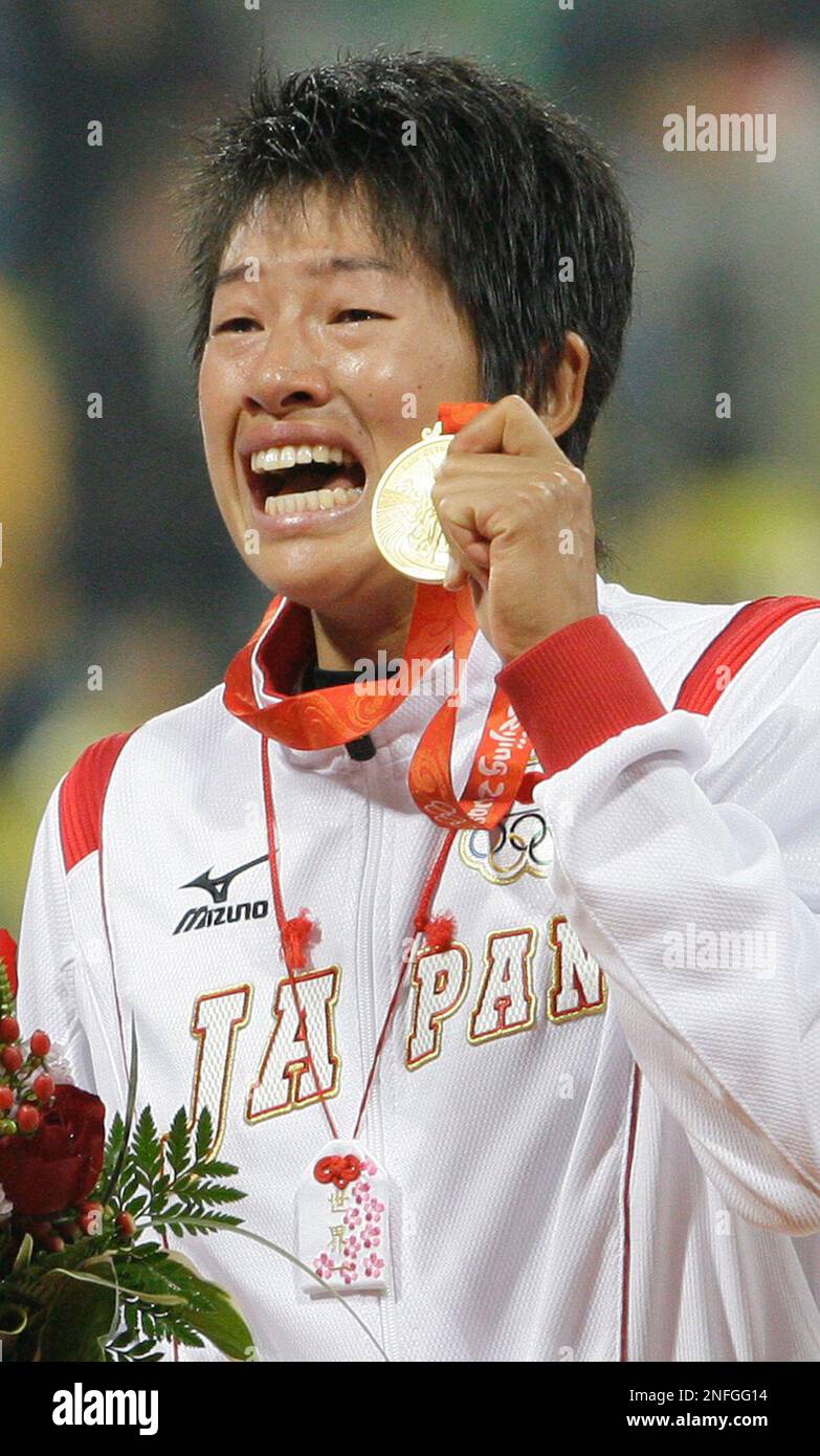 Japan pitcher Yukiko Ueno cries as she hold up her gold medal after ...