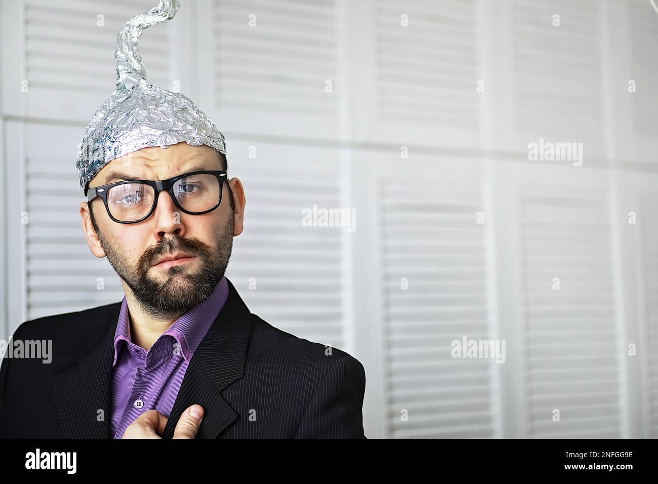 Bearded funny man in cap of aluminum foil. Concept art phobias ...
