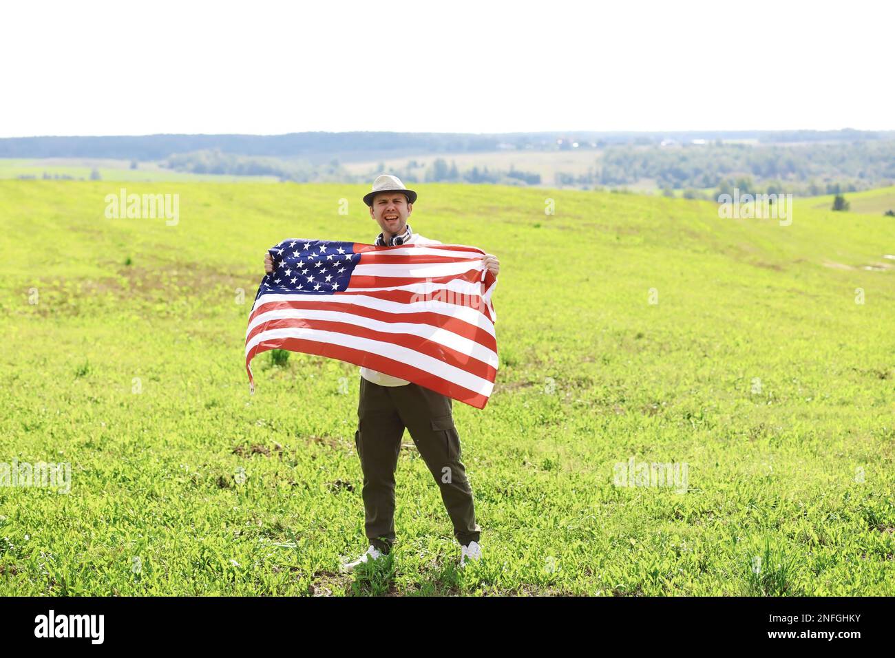Man waving American flag standing in farm agricultural field , holidays ...