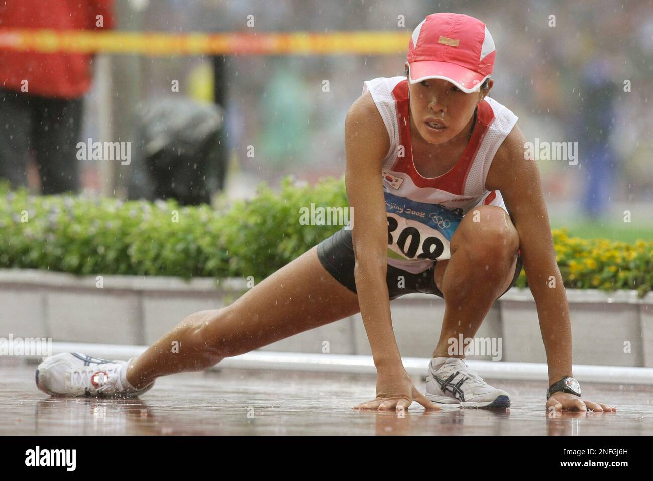 South Korea's Kim Mi-jung stretches her leg after competing in the ...
