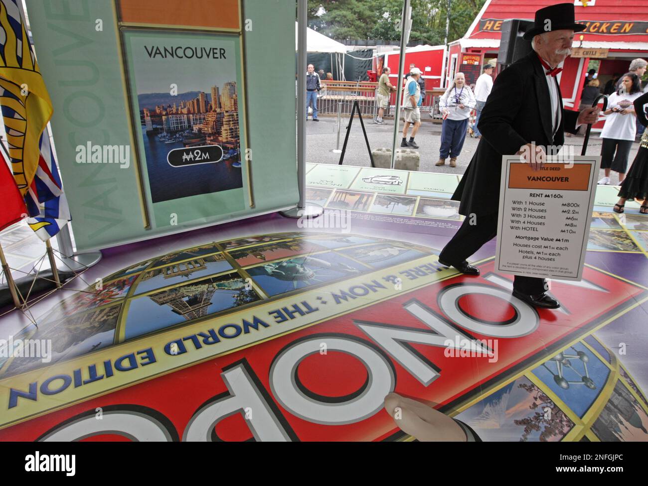 A performer dressed as Mr. Monopoly carries the Title Deed to Vancouver ...