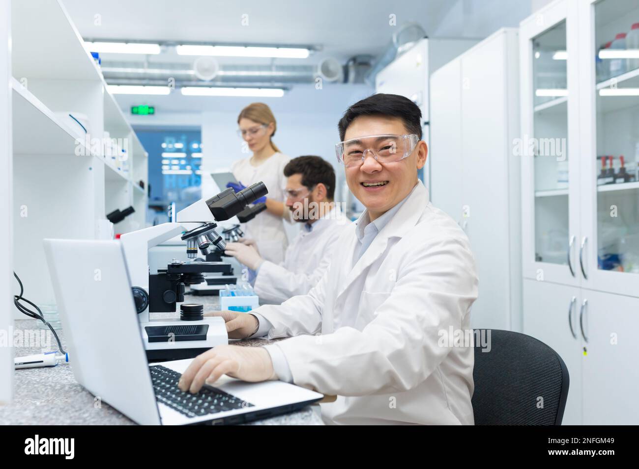 Portrait of asian lab technician, man with team group of people working ...