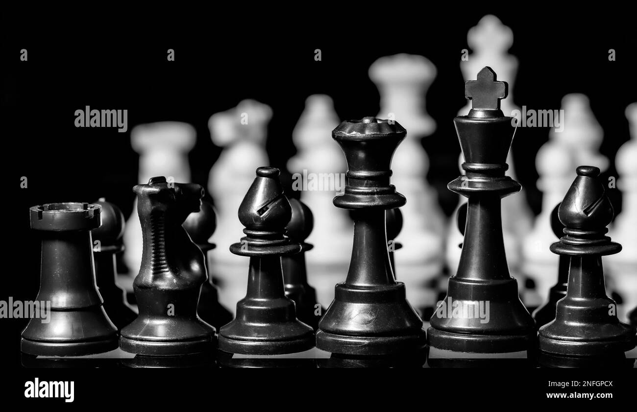 Close up of Chess pieces on a reflective mirror board surface with a ...
