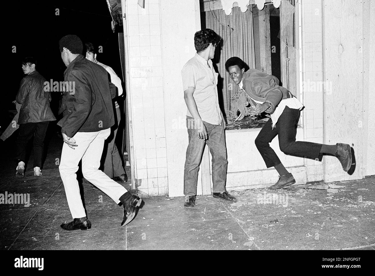 A youth grabs an item from the smashed display window of the Union Mens ...