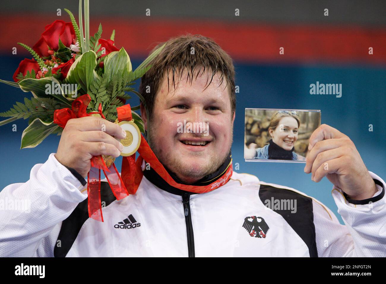 Matthias Steiner of Germany holds the gold medal he's dedicating to his ...