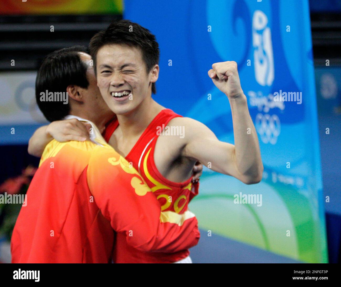 China's gymnast Lu Chunlong, right, is hugged by a member of the ...