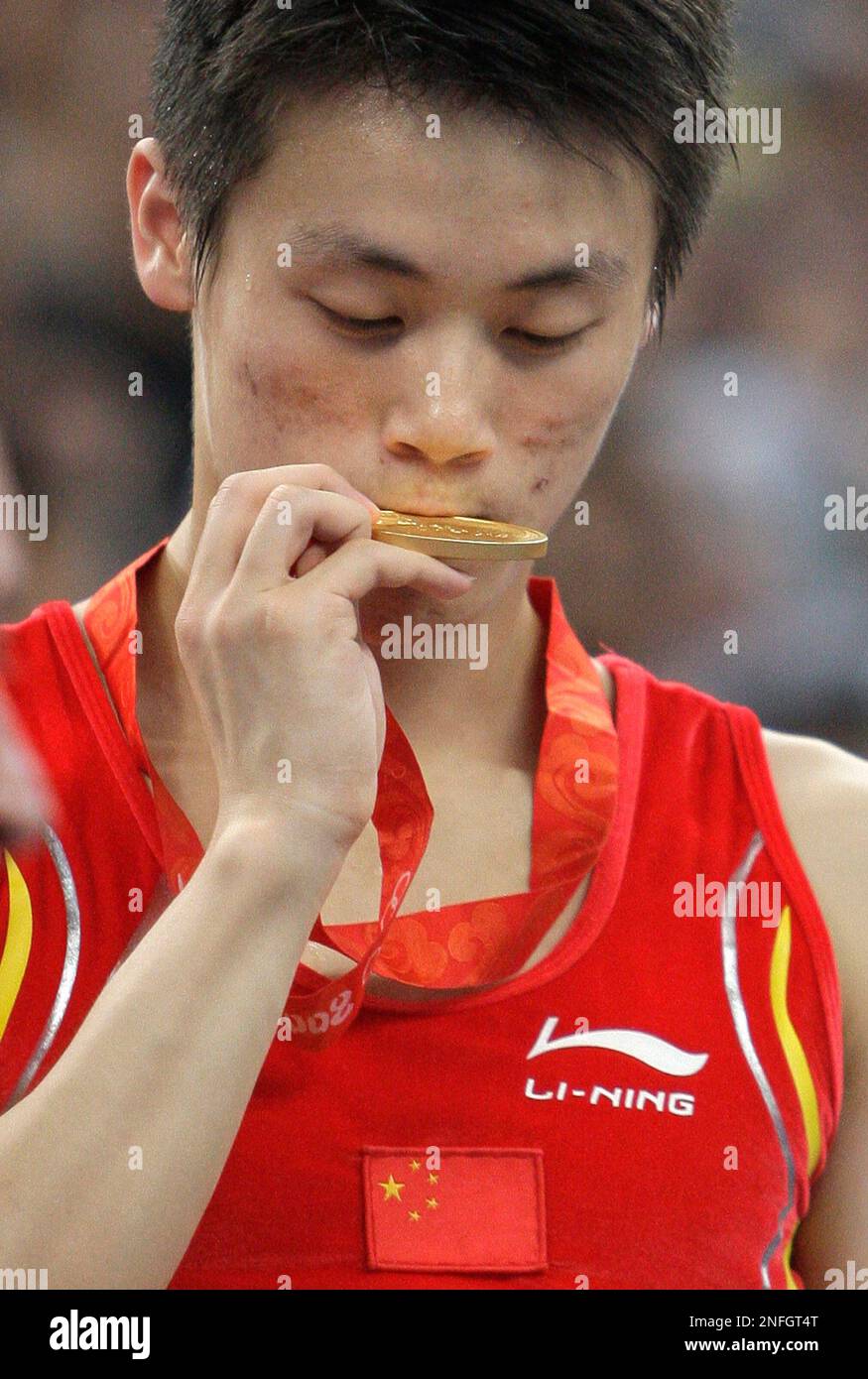 China's gymnast Lu Chunlong kisses his gold medal on the podium during the mens' trampoline ...