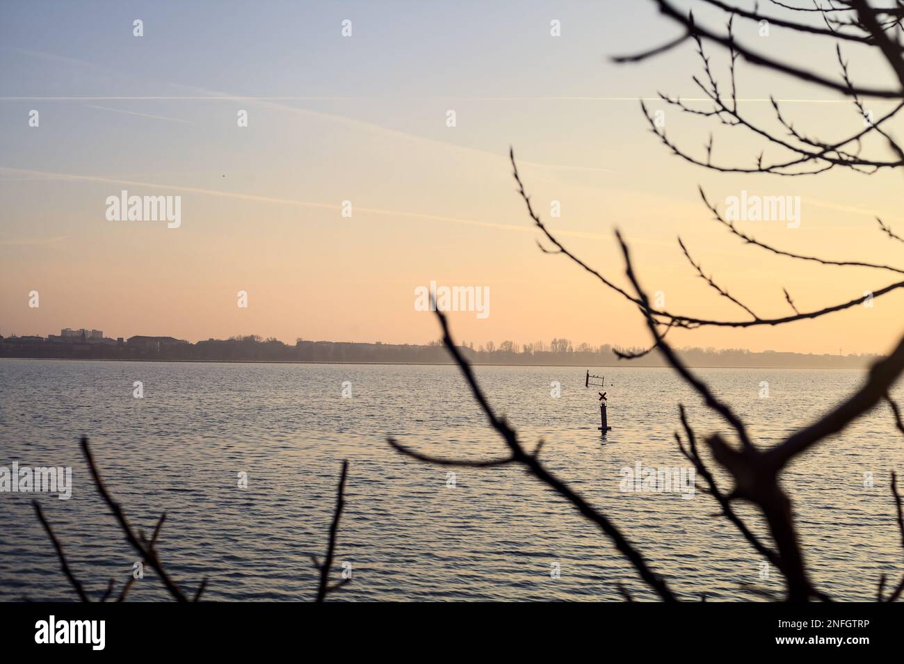Lake at sunset with the opposite shore on the horizon Stock Photo - Alamy