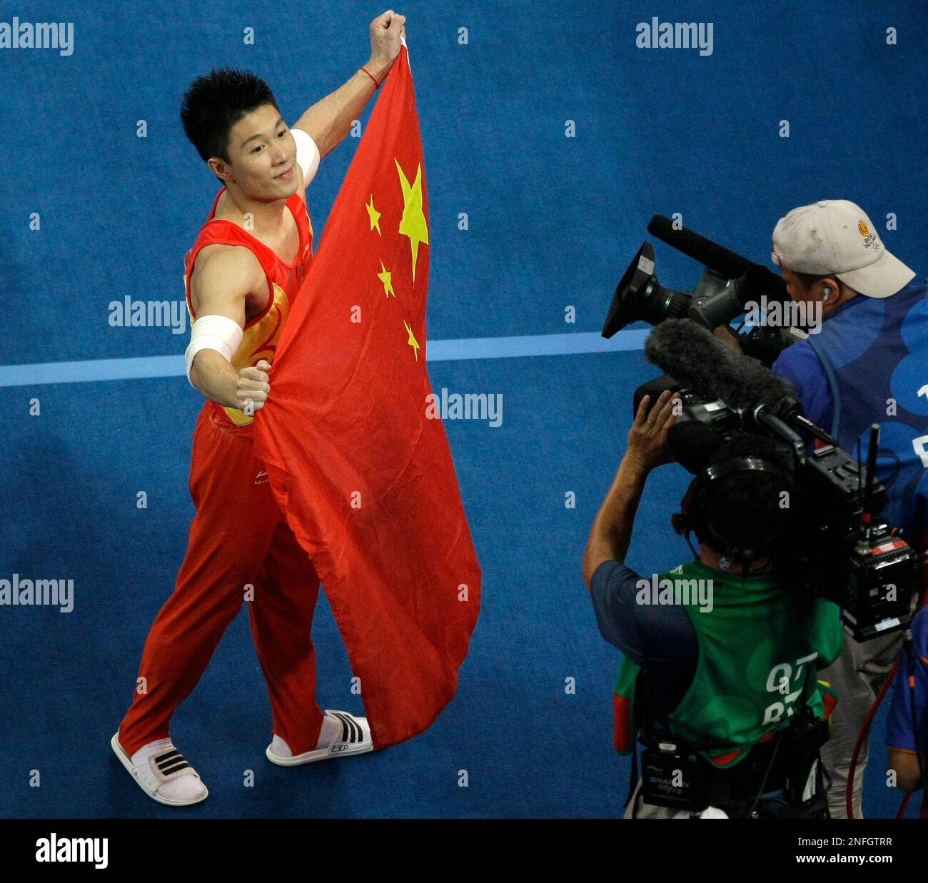 China's gymnast Li Xiaopeng celebrates with his country's flag after ...
