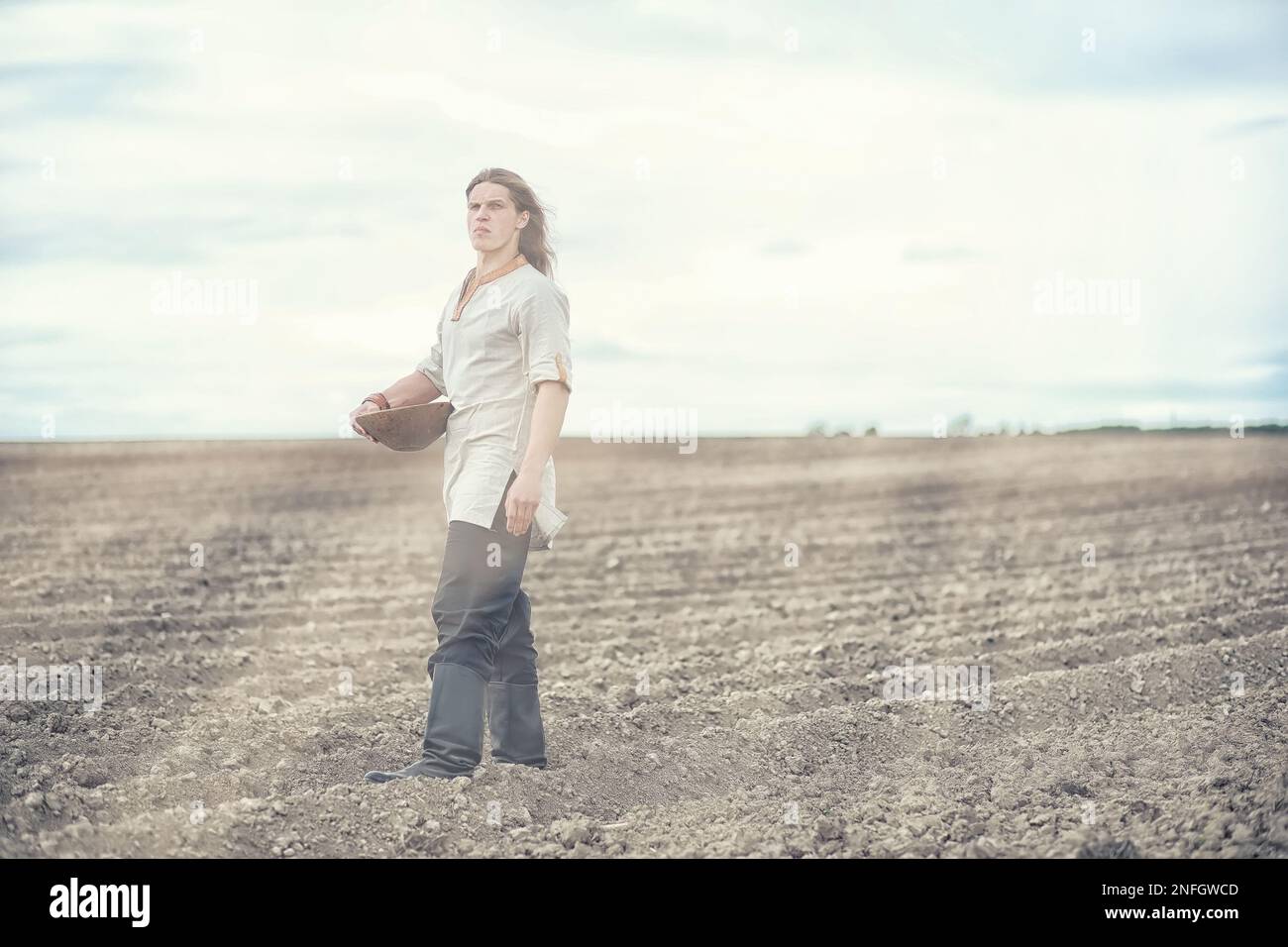 A young peasant of the Scandinavian appearance sows the field with ...
