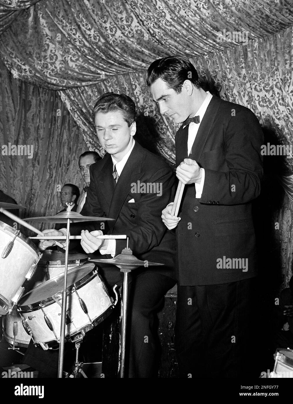 U.S. film actor Jackie Cooper, gets a lesson on drums from Swing ...