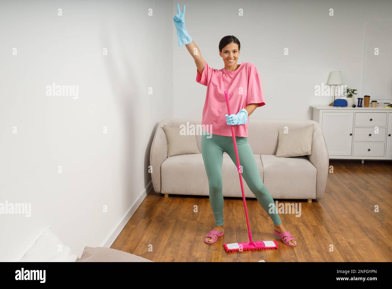 Full-size picture of happy smiling girl doing house cleaning. Washing floors. Cute young woman ...