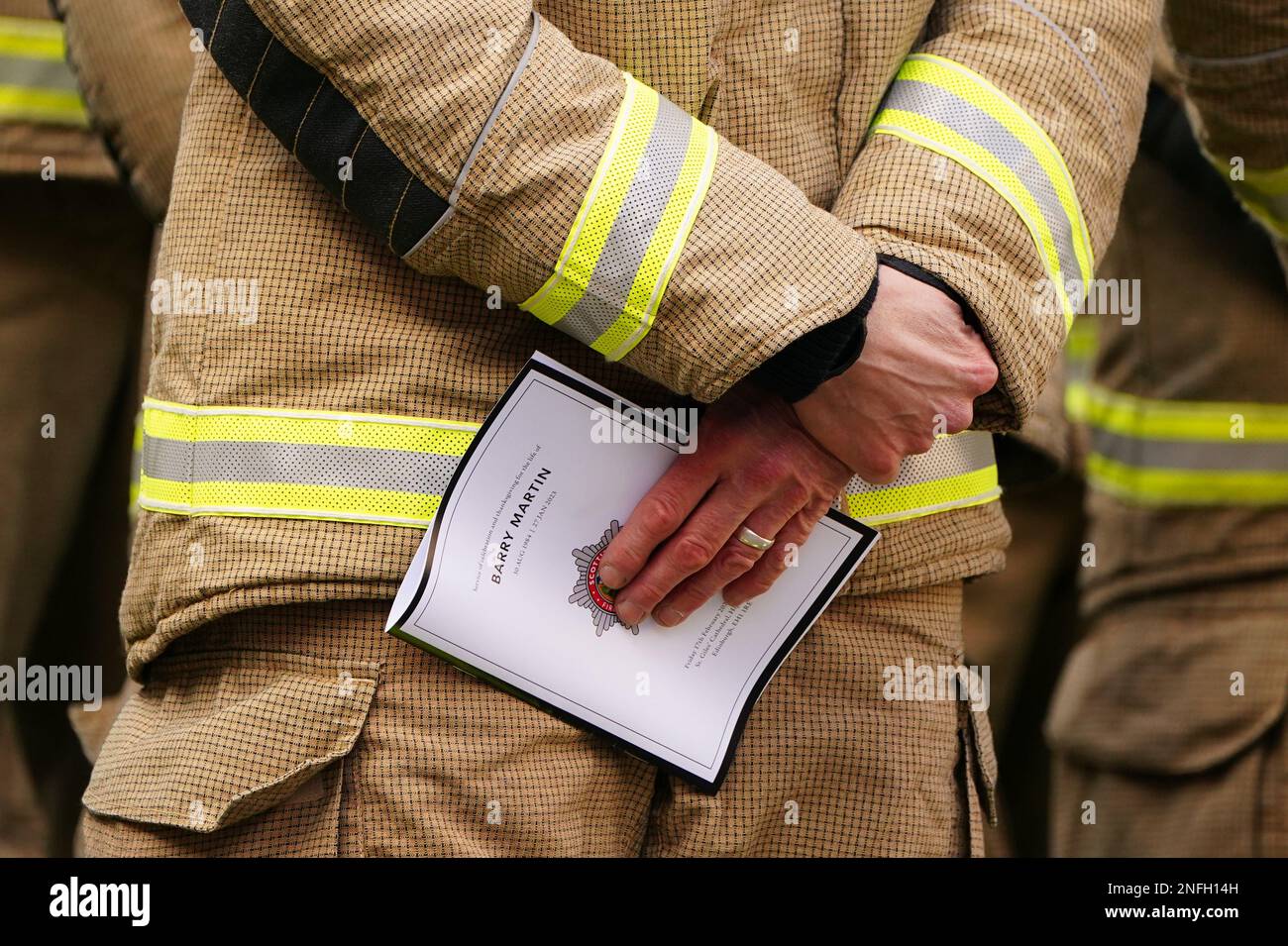 A firefighter holding a copy of the Order of Service for the funeral of ...