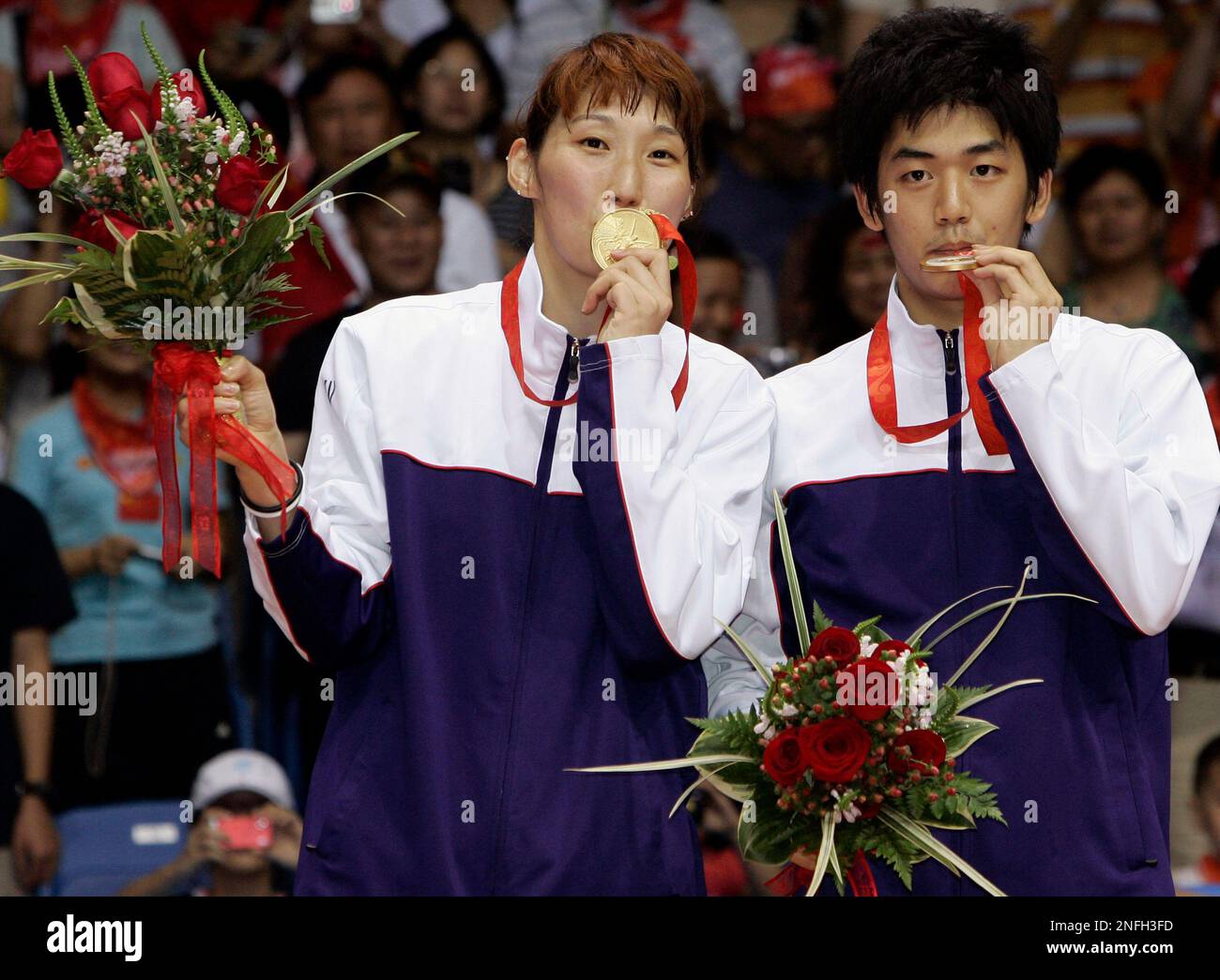 South Korea's Lee Hyojung, left, and Lee Yongdae, kiss their gold medals during the awards ...