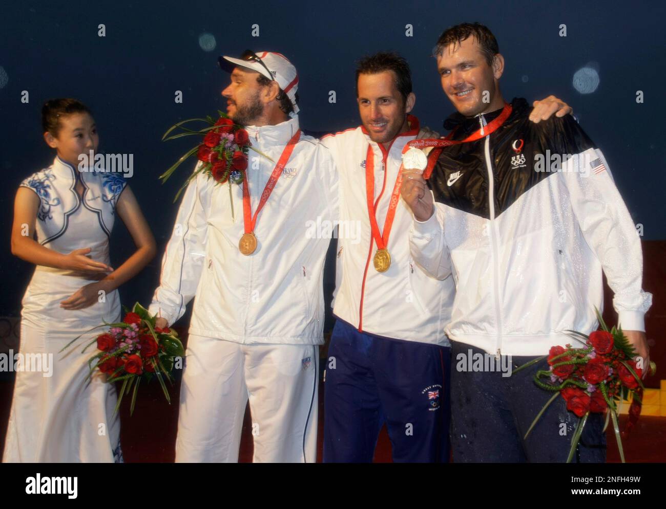 Britain's Ben Ainslie, center, poses with the gold medal of the Finn ...