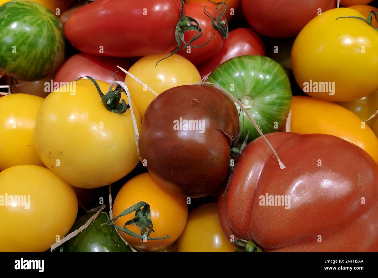 Close-up on a stack of mix tomatoes for sale on a market stall Stock ...
