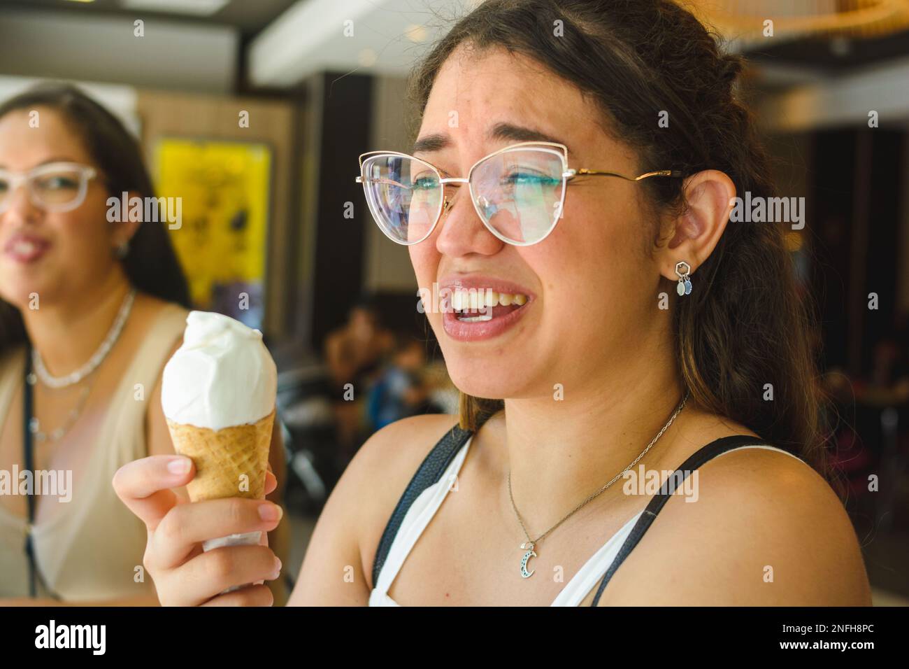 young latin woman with dental sensitivity, her teeth hurt from eating ...