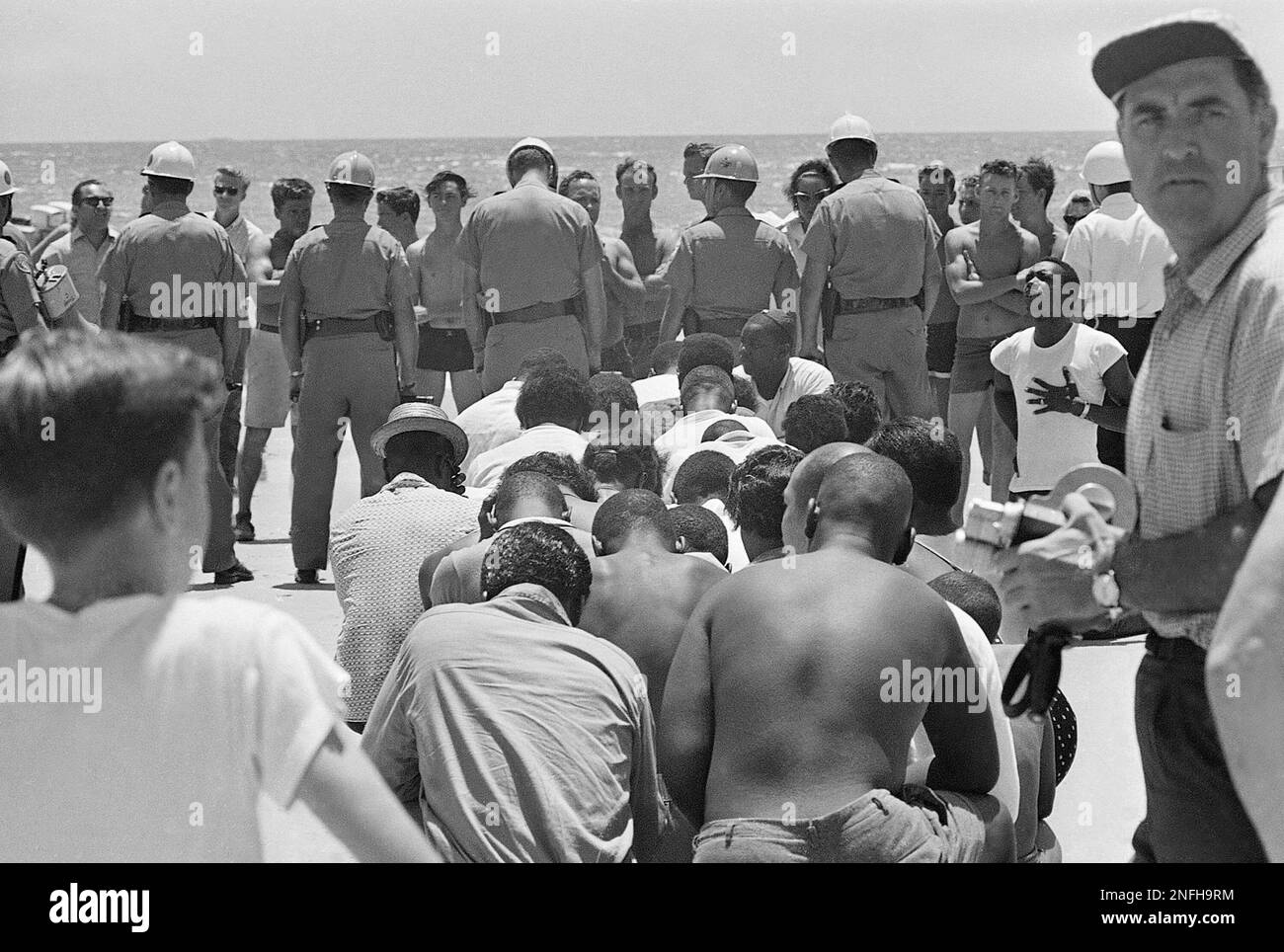 An unidentified white segregationist, background, blocks the path as ...