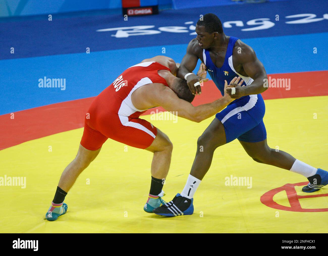 Cuba's Mijain Lopez wearing blue wrestles with Russia's Khasan Baroev ...