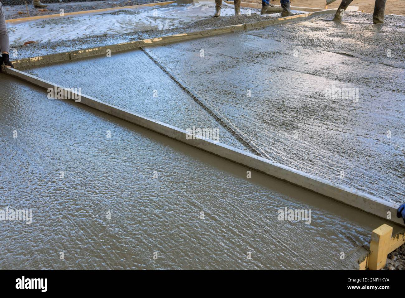 As construction worker leveled cement sidewalk that had been wet with ...