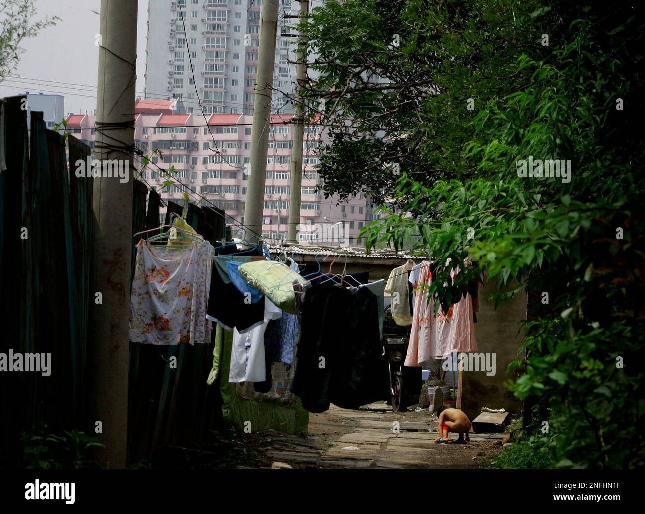 The Child of Chinese migrant workers plays in the alley of a poor ...