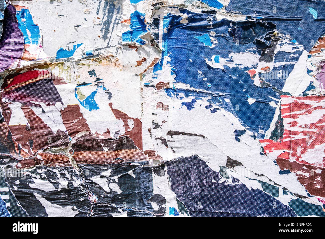 Torn paper collage background on an old poster on a street wall ...