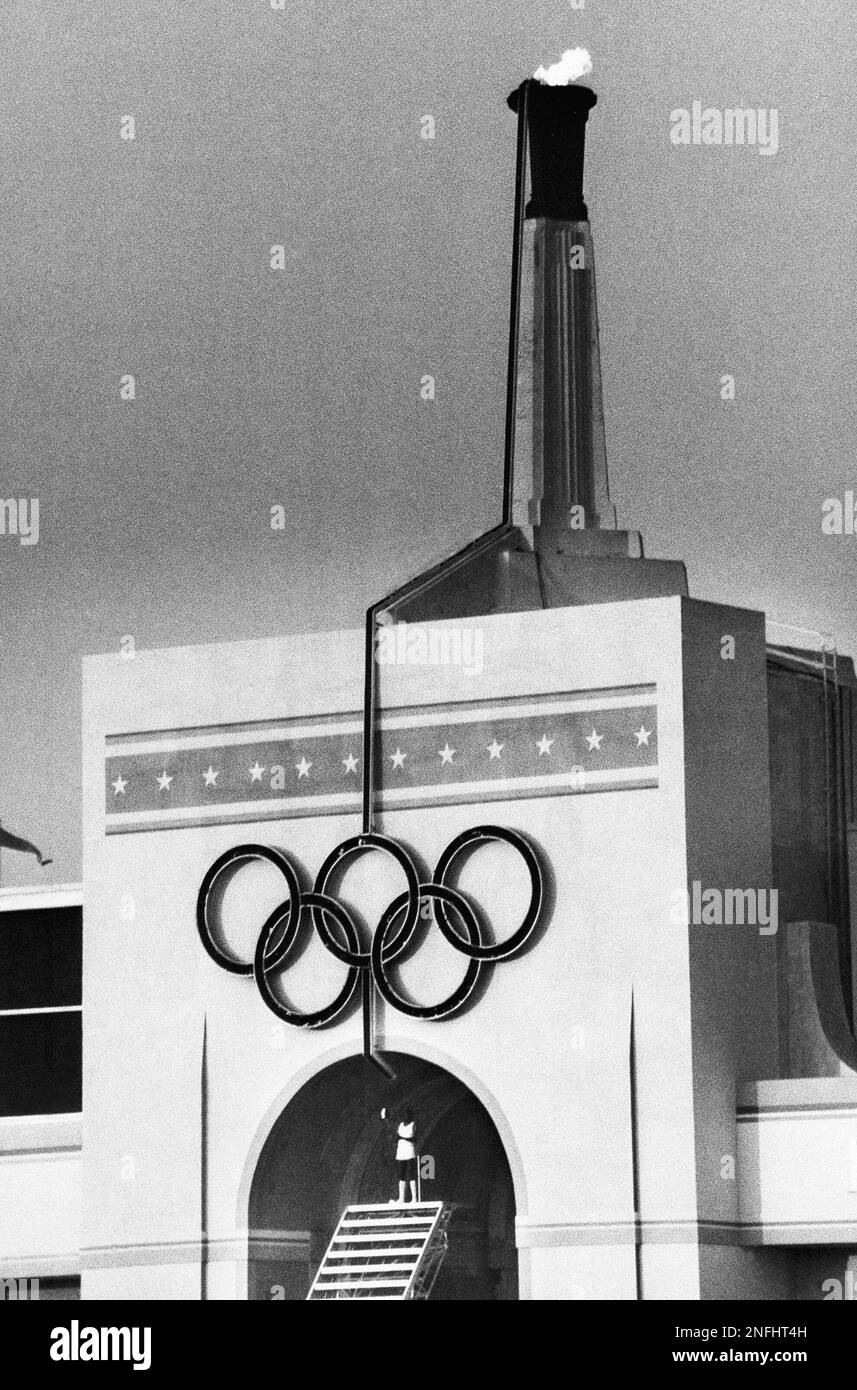 1960 U.S. gold medal decathlete Rafer Johnson lowers the Olympic torch ...